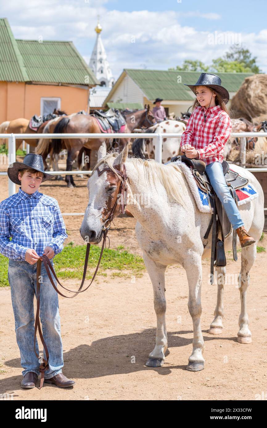 cowboy brother holds the horse of his sister by the reins Stock Photo ...
