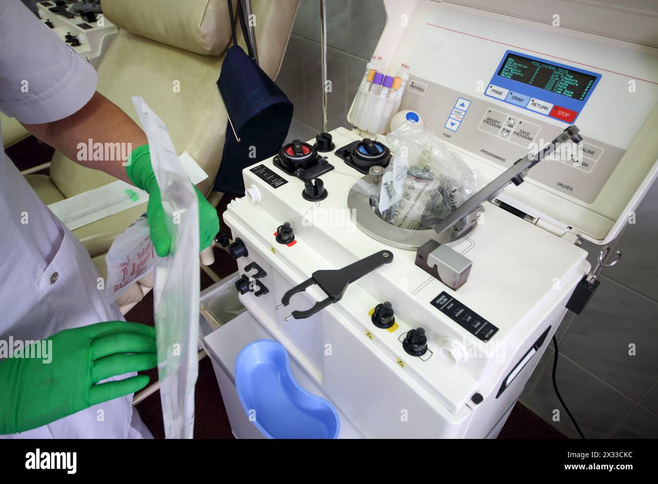 medic in rubber gloves holds package beside Plasma Collection System ...