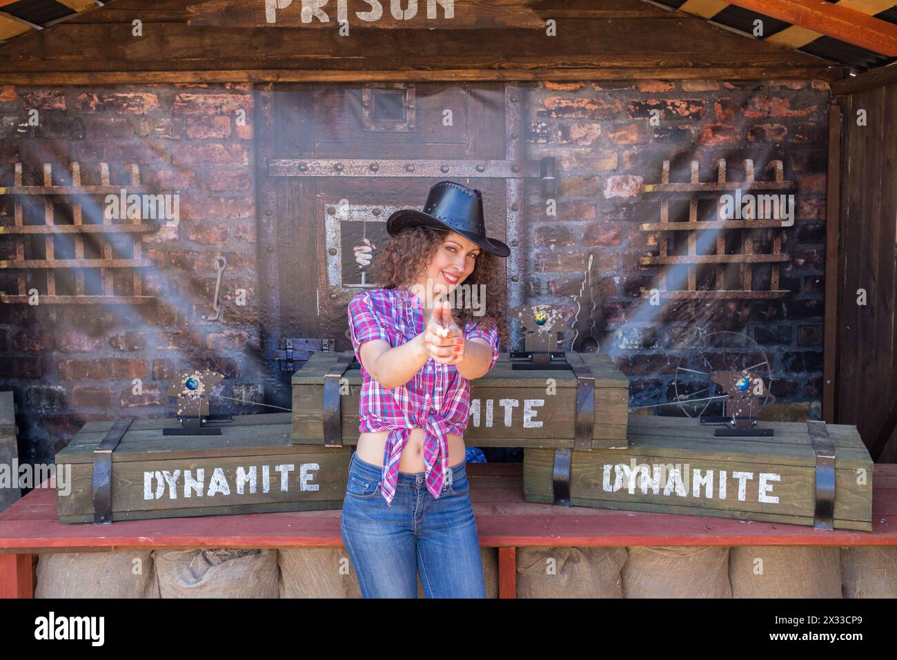 cowboy lady gesticulates on backgroud of boxes of dynamite Stock Photo ...