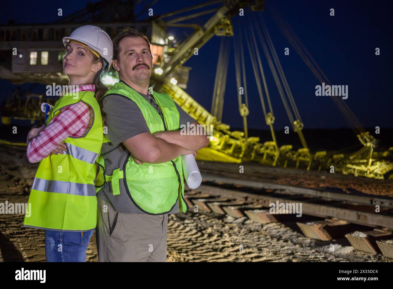two workers stand back to back on background of career stacker Stock ...