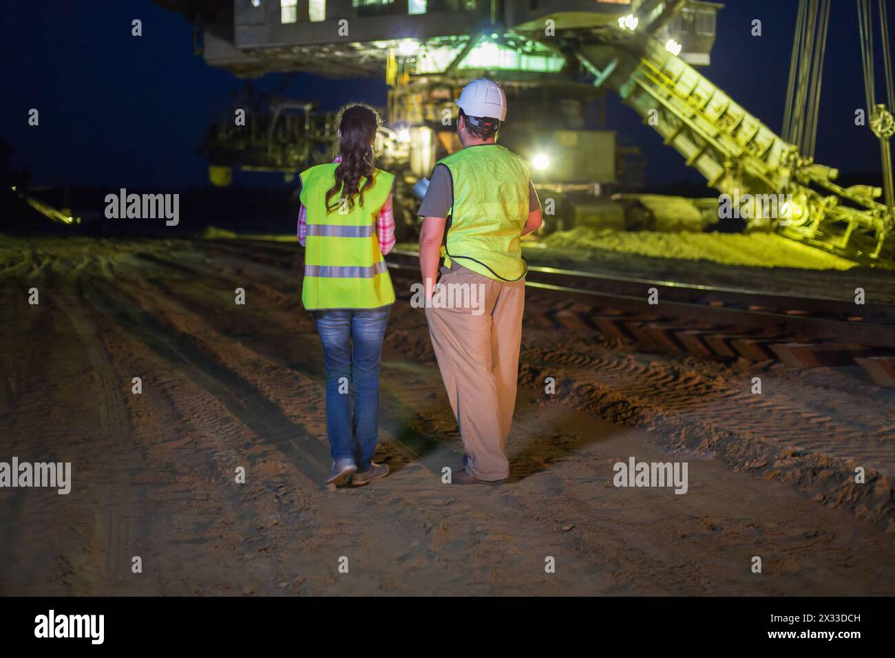 two workers go across the sand career stacker Stock Photo - Alamy