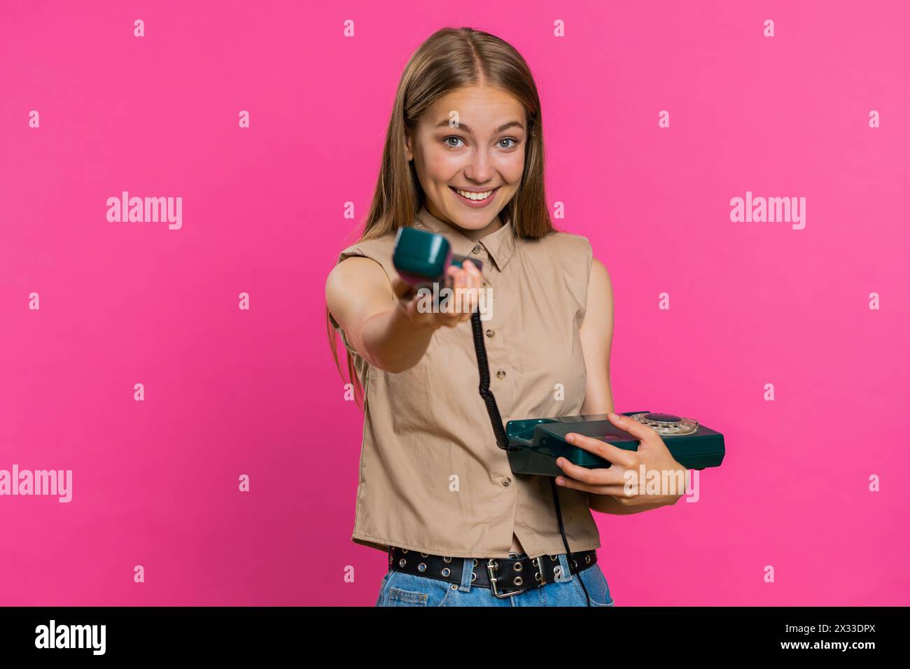 Hey you, call me back. Young woman talking on wired landline vintage ...