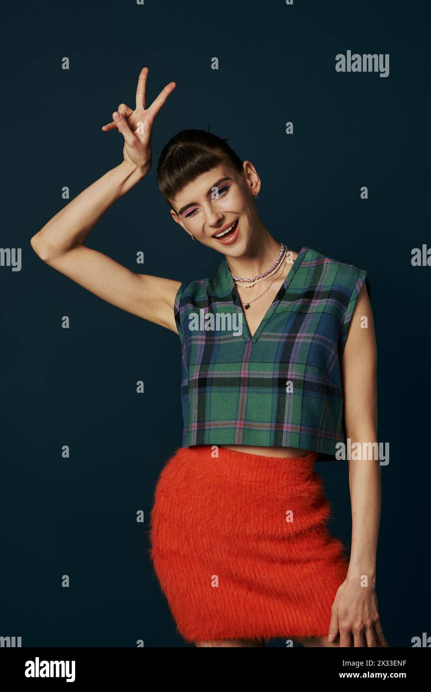 A woman strikes a stylish pose with her hand raised Stock Photo - Alamy