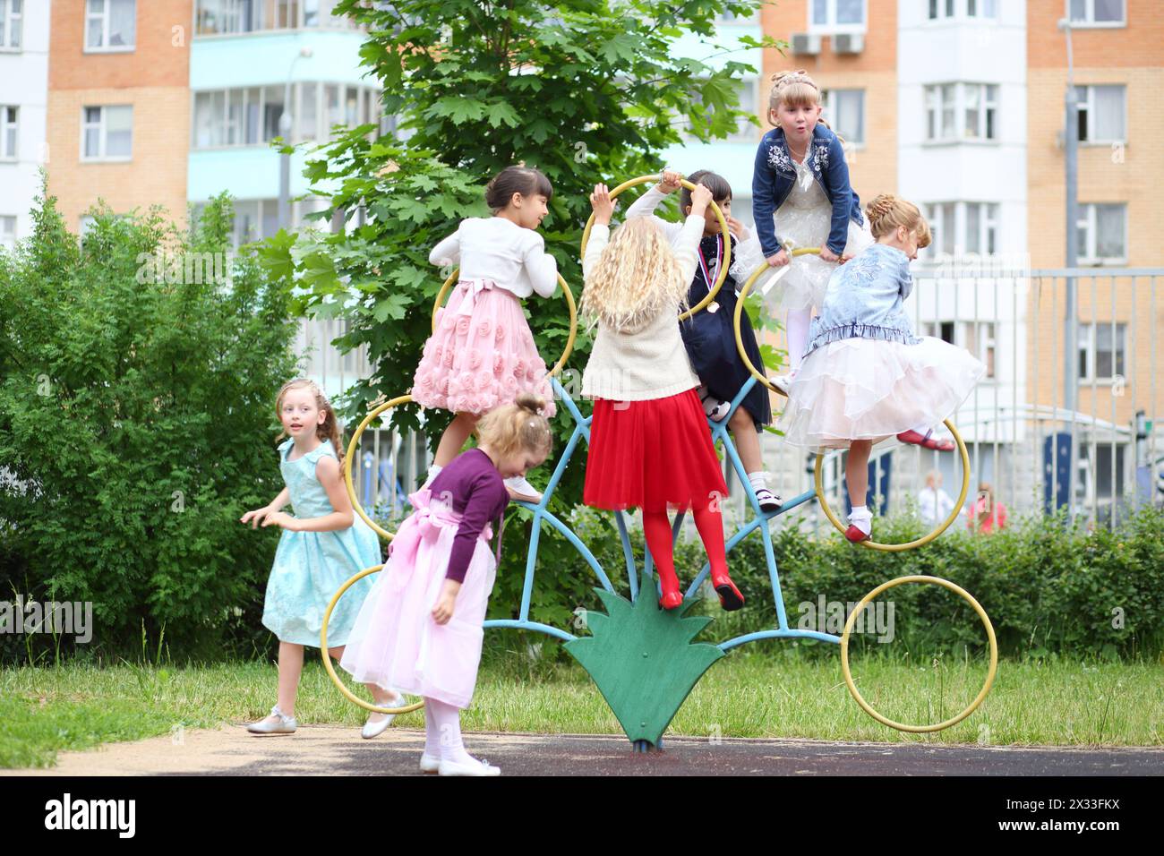 Seven little girls in elegant dresses play at the playground in ...
