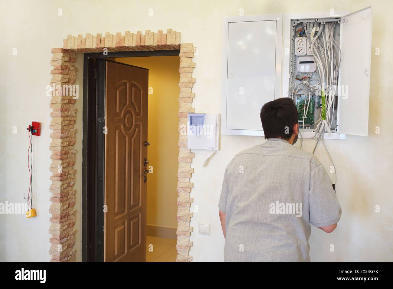 electrician working on electrical installations in fuse box in the ...