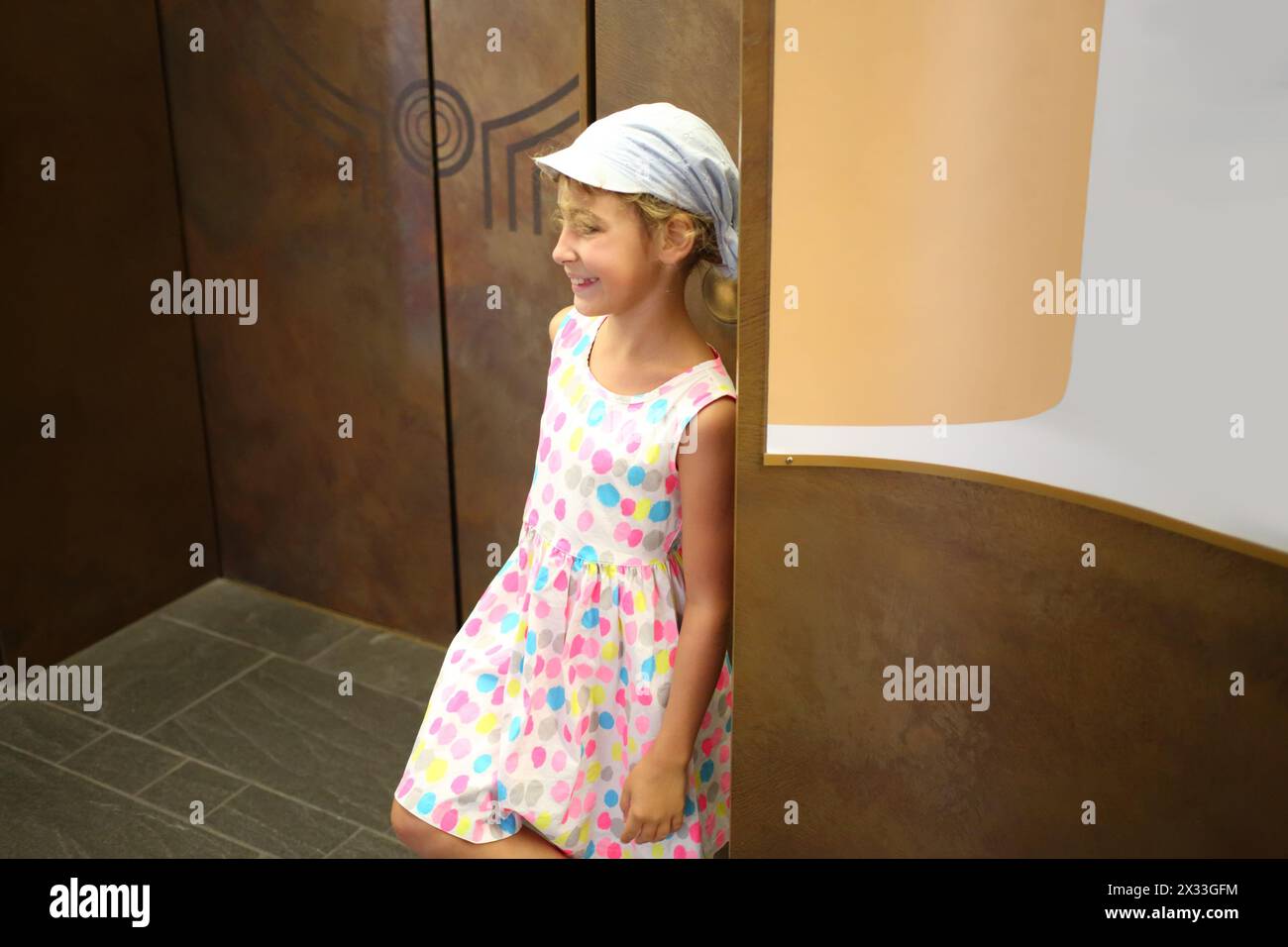 Little girl at colored dress is standing near door in Museum Stock ...