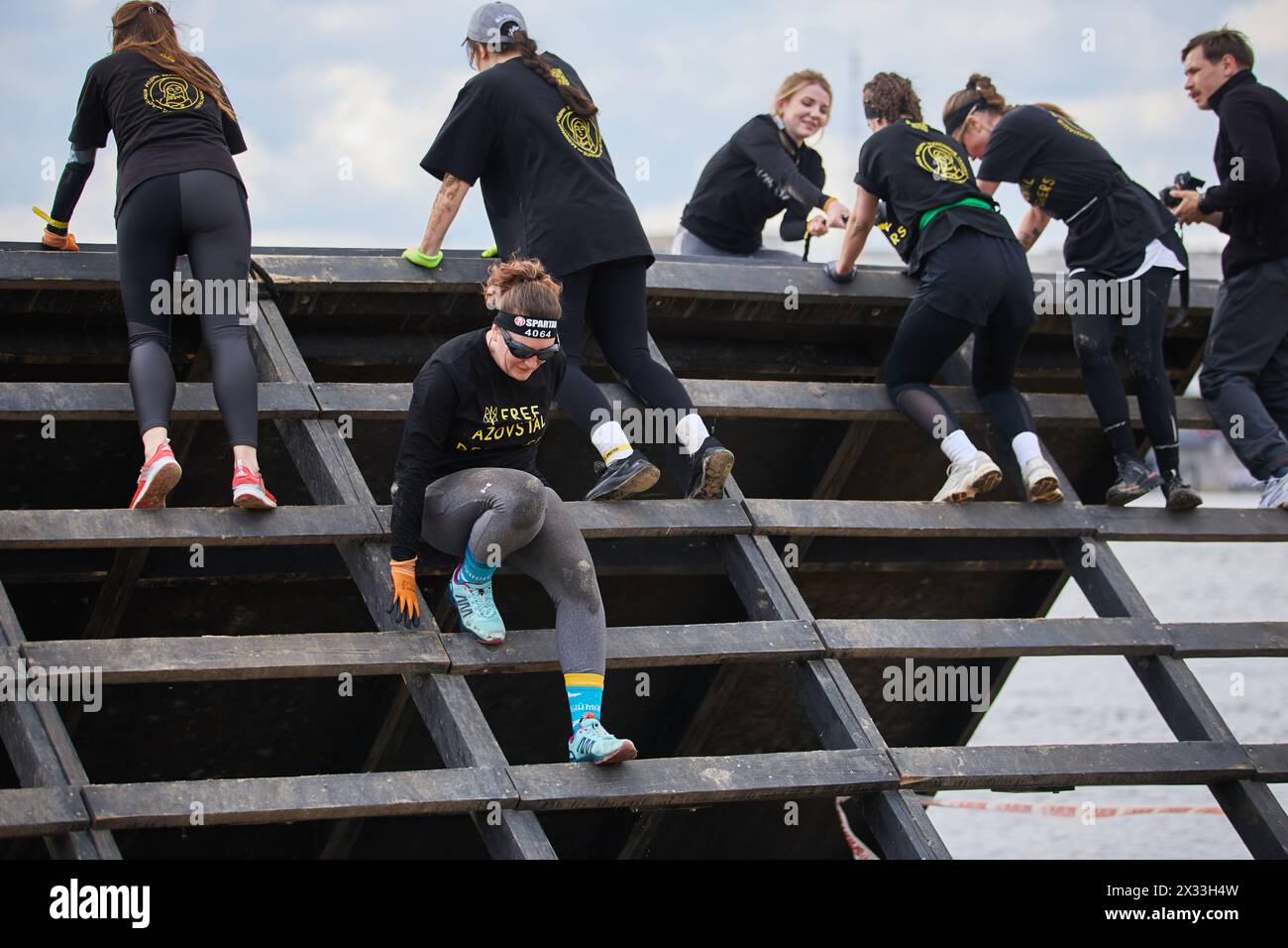 Group of women climbing the slip wall obstacle at the Spartan Race ...
