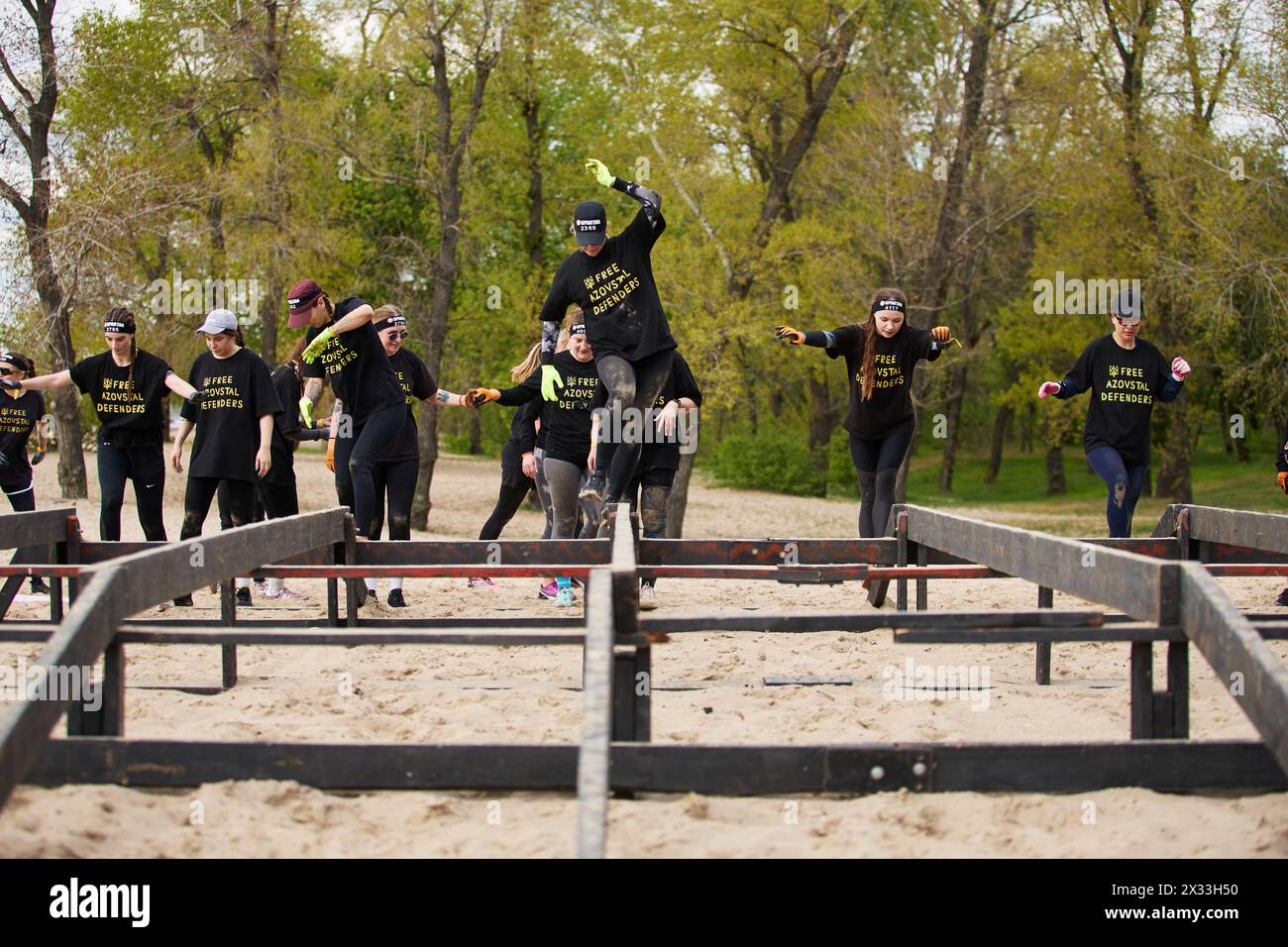 Female athletes walking on a thin balance beam on the beach during the ...