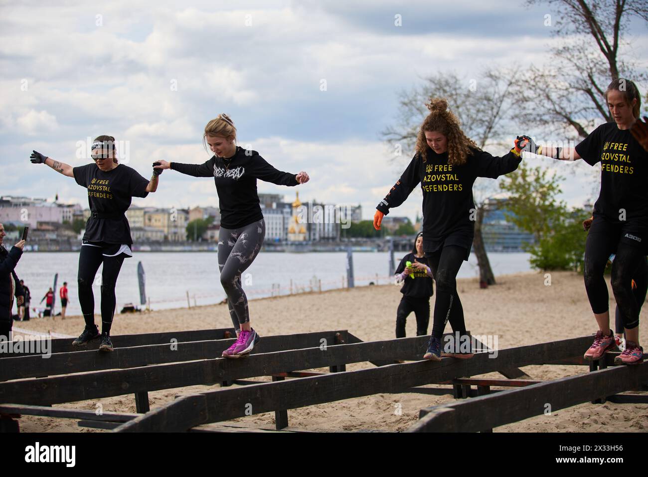 Group of females balancing on a balance beam at the Spartan Race ...