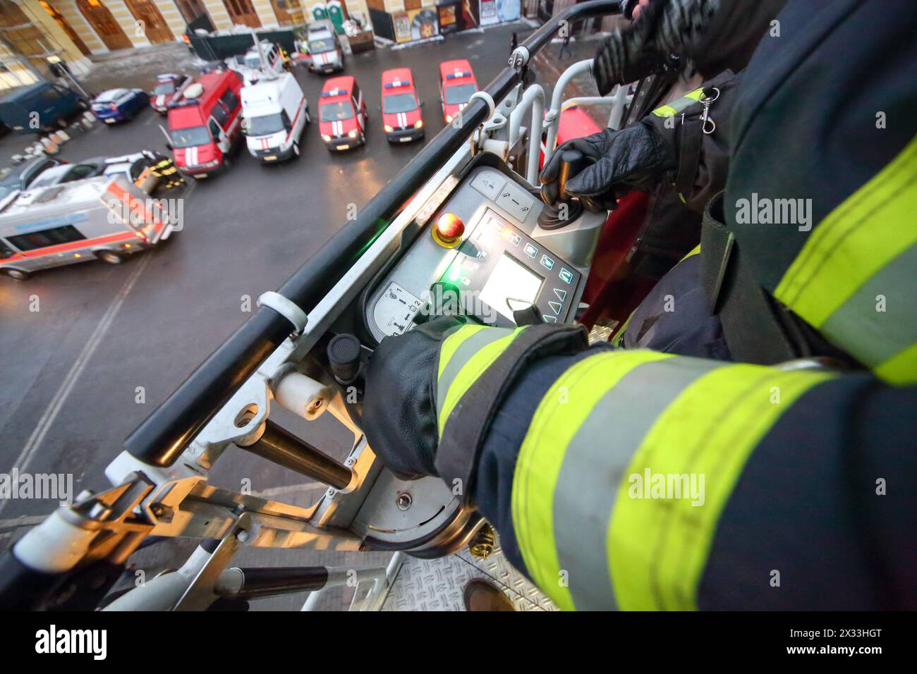 firefighter operates fire truck ladder out of the cradle Stock Photo ...