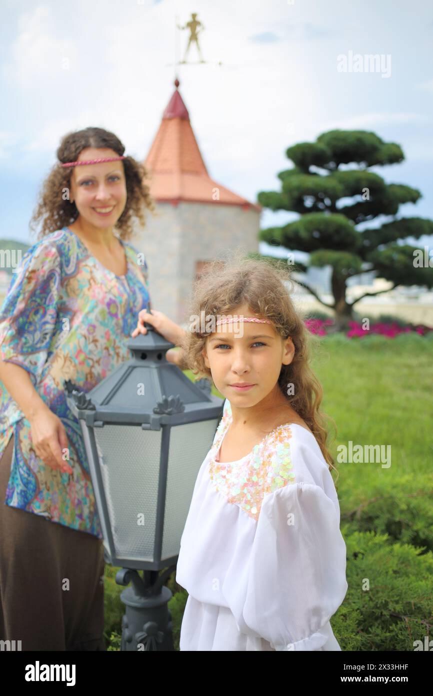 Mother and daughter in ethnic dress near the medieval castle, focus on ...