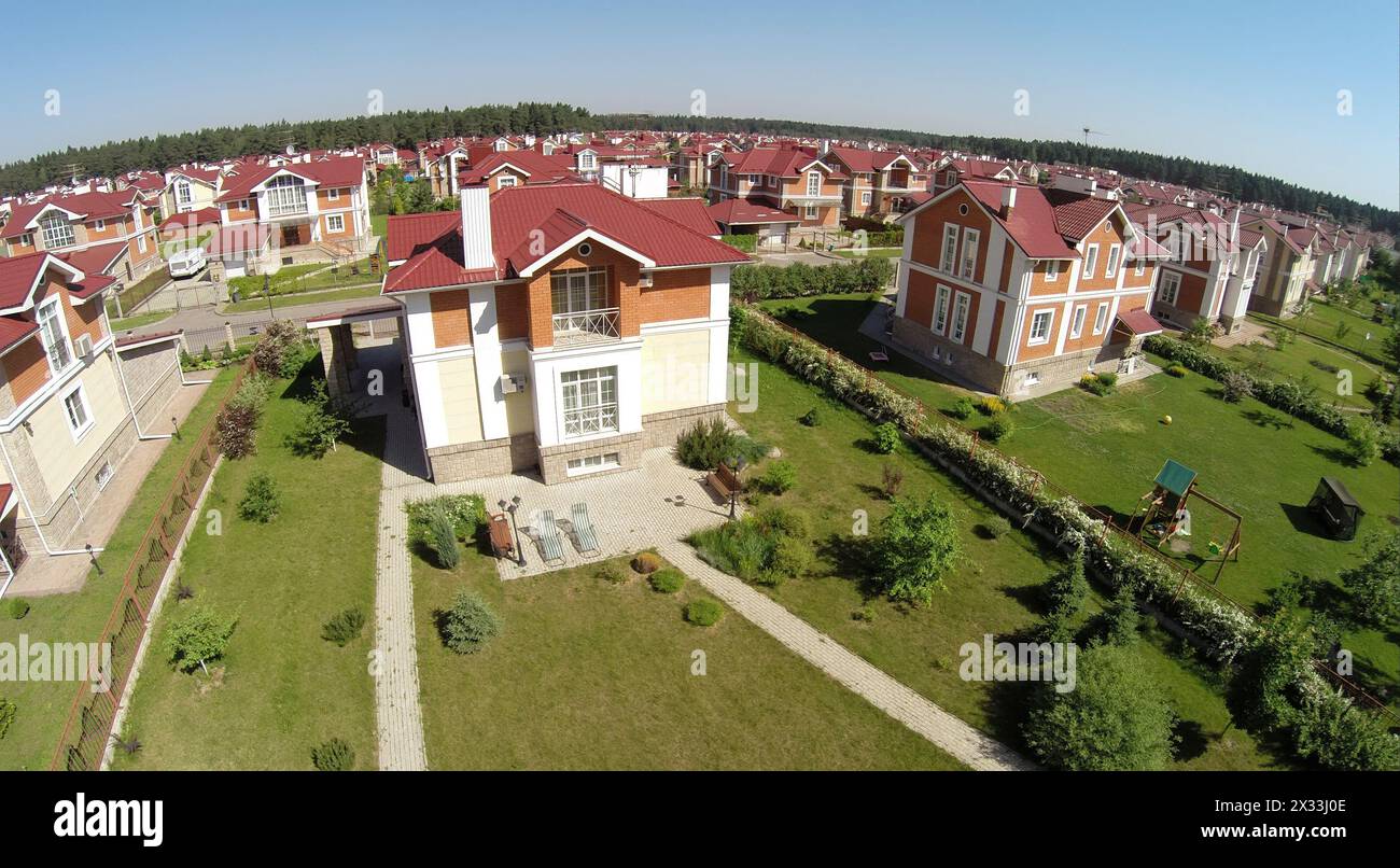 Aerial view many similar houses in gated development at sunny summer ...
