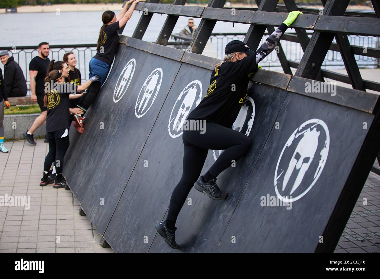 Women climbing on the A-shaped wooden wall in a "stairway to sparta ...