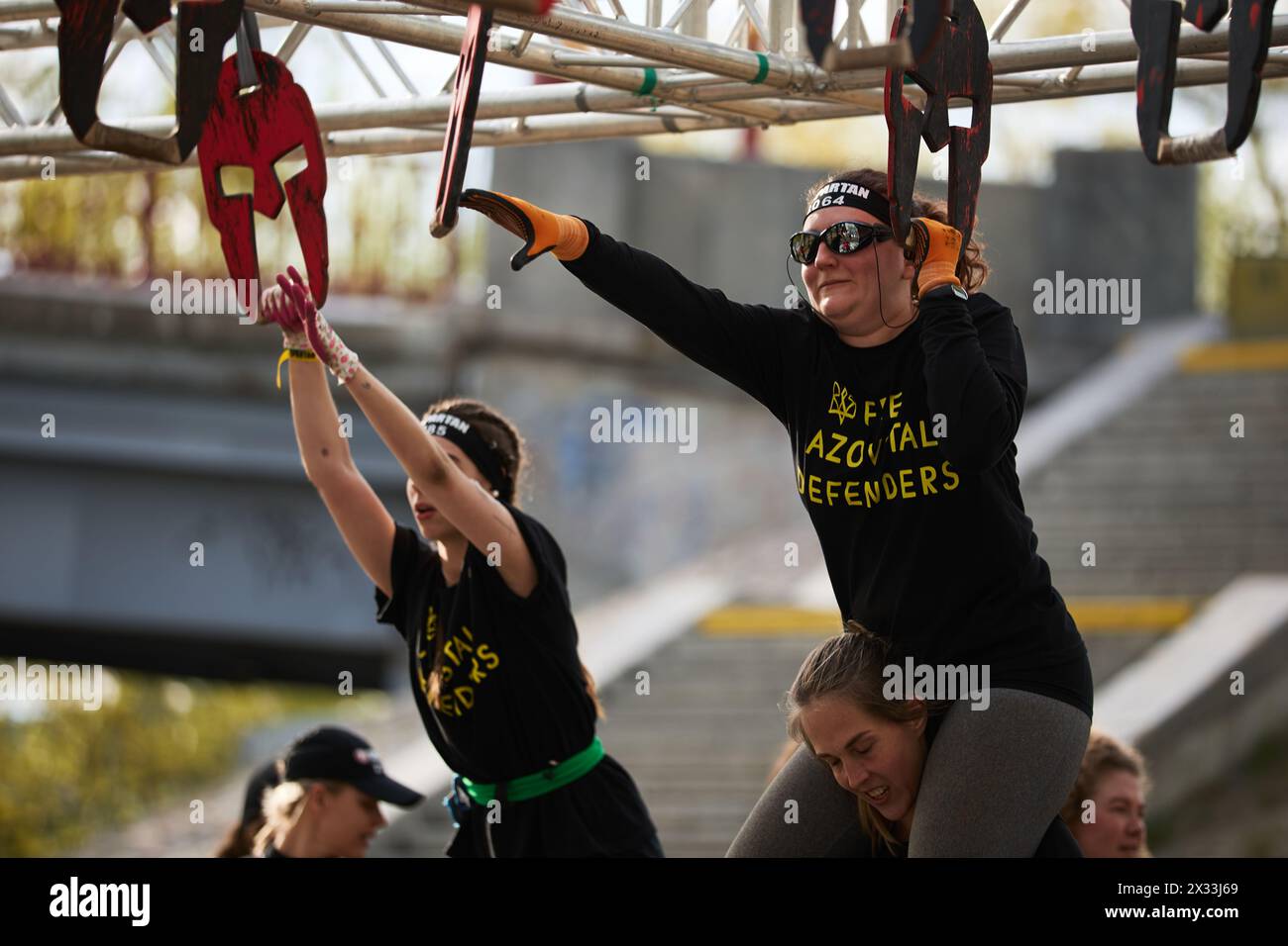 Women exercising on multi rig ring swing at the Spartan Race ...