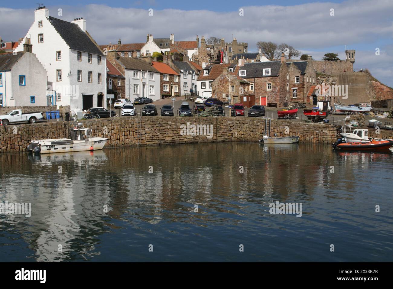 Waterfront buildings reflected in Crail harbour Fife Scotland April ...