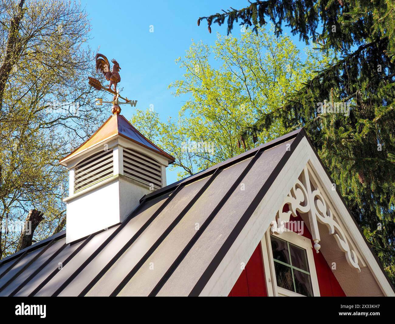 Copper rooster weathervane and cupola on red shed or barn with dark ...