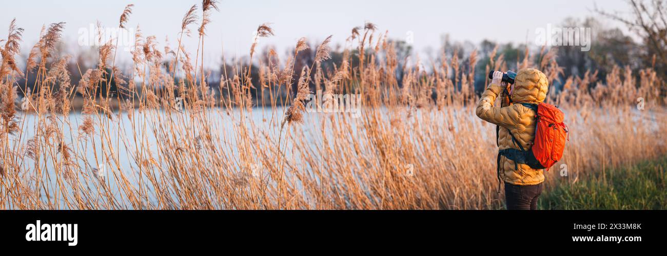 Bird watching at lake. Ornithologist with binoculars observe wildlife ...