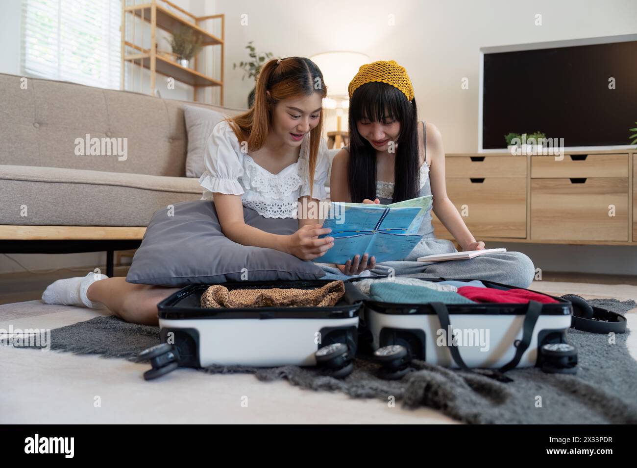 Friendship. Travel together. Two asian young woman friends packing for ...