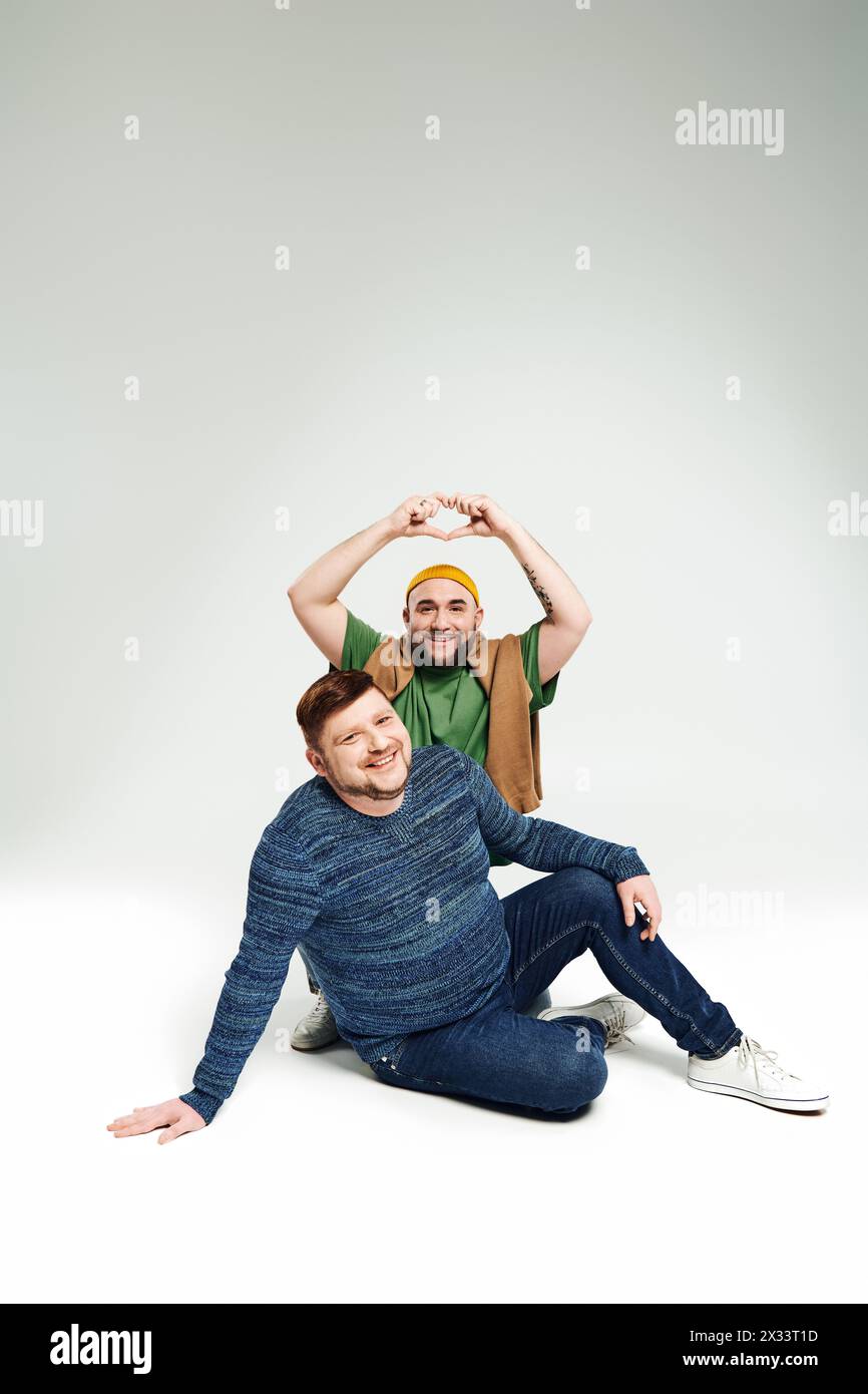 Two men sitting together, posing for a picture Stock Photo - Alamy