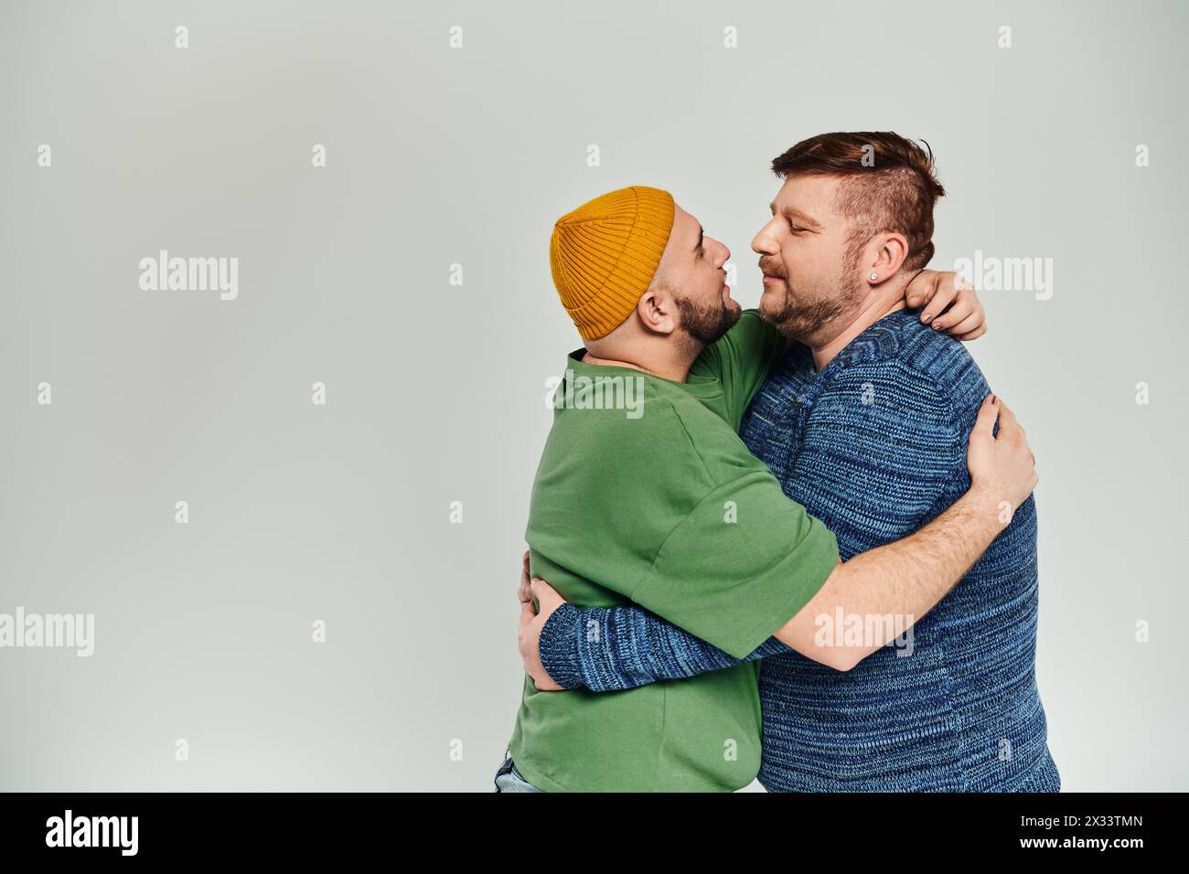 A close-up moment of two men tenderly embracing each other, showcasing ...