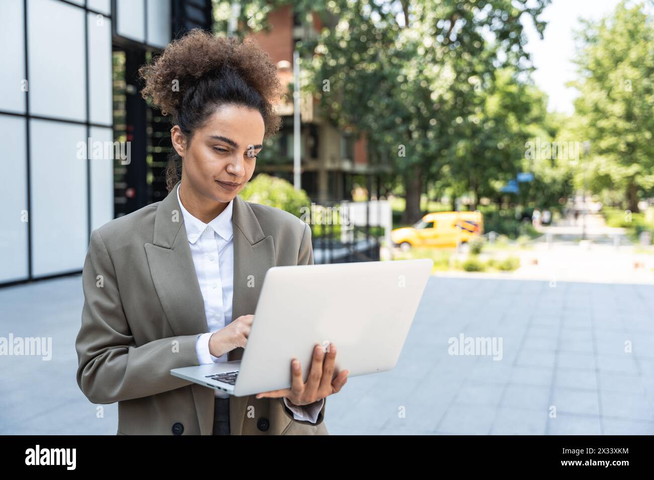 Portrait of young successful businesswoman office worker using laptop ...