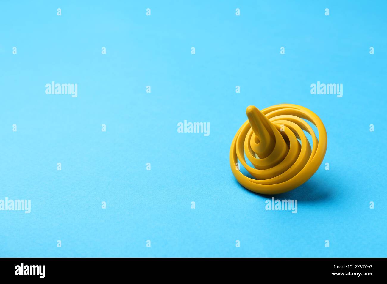 One yellow spinning top on light blue background, space for text Stock ...