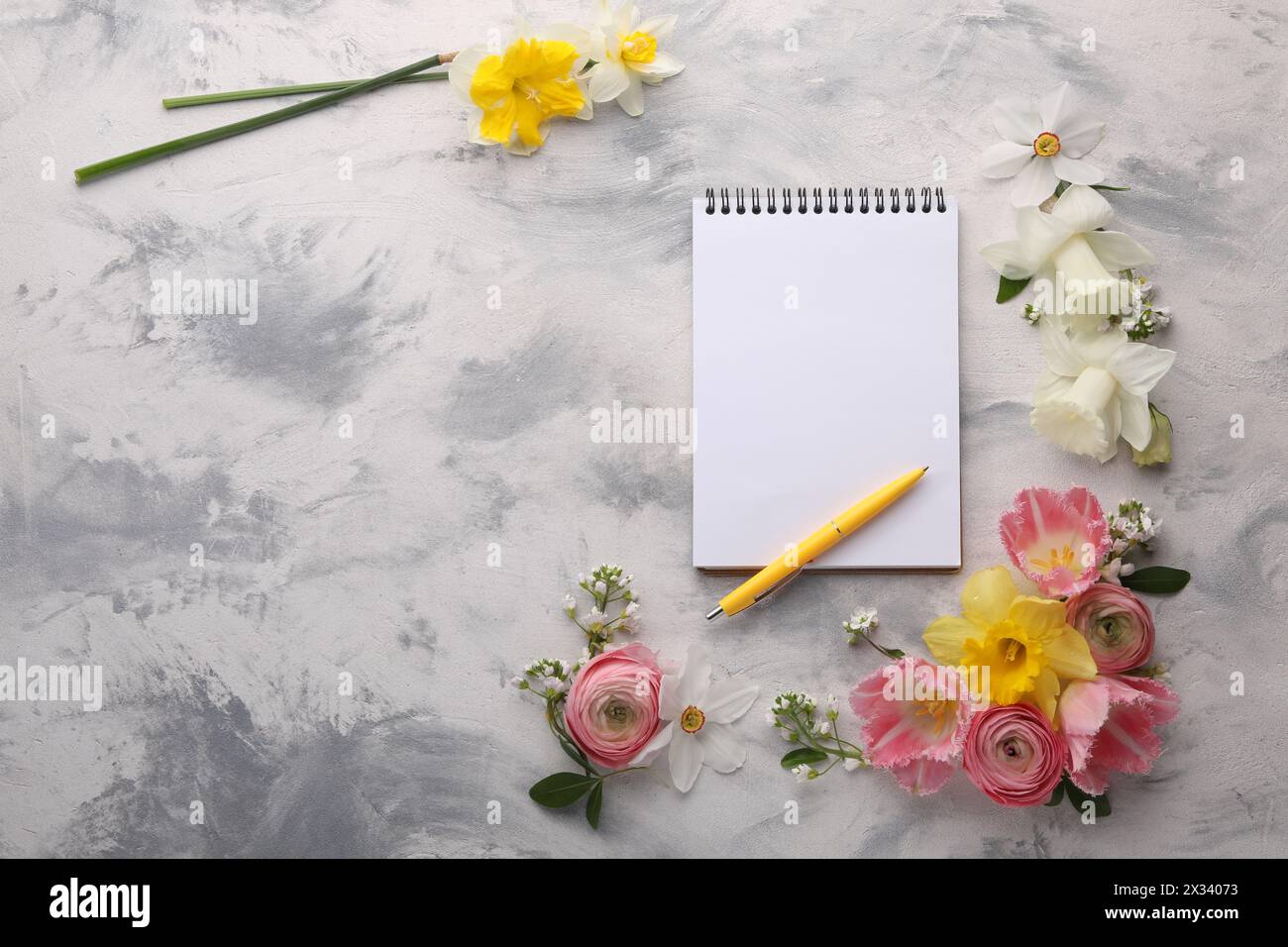 Guest list. Notebook, pen and beautiful flowers on gray textured ...