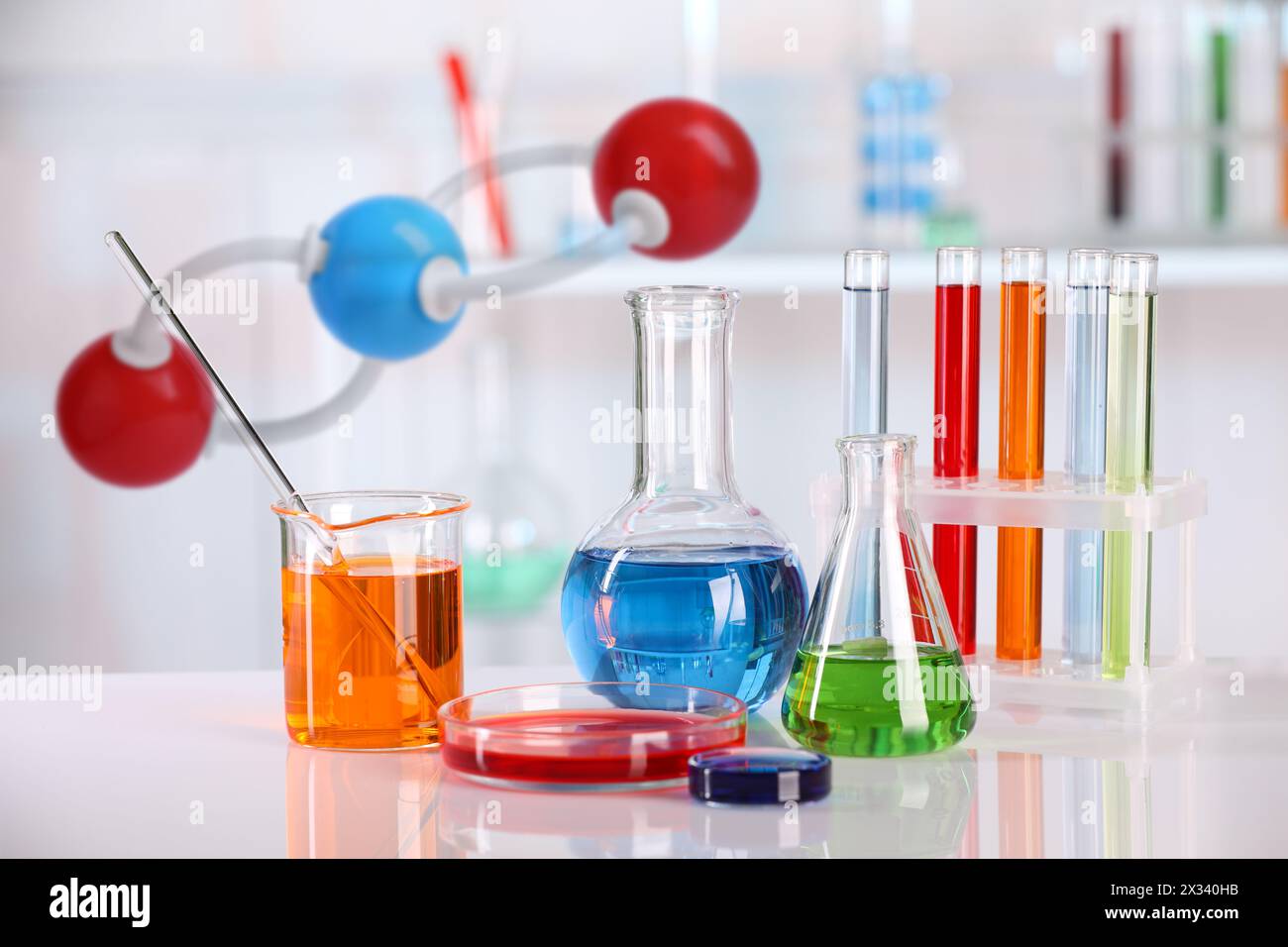 Different glassware and molecule model in laboratory Stock Photo - Alamy