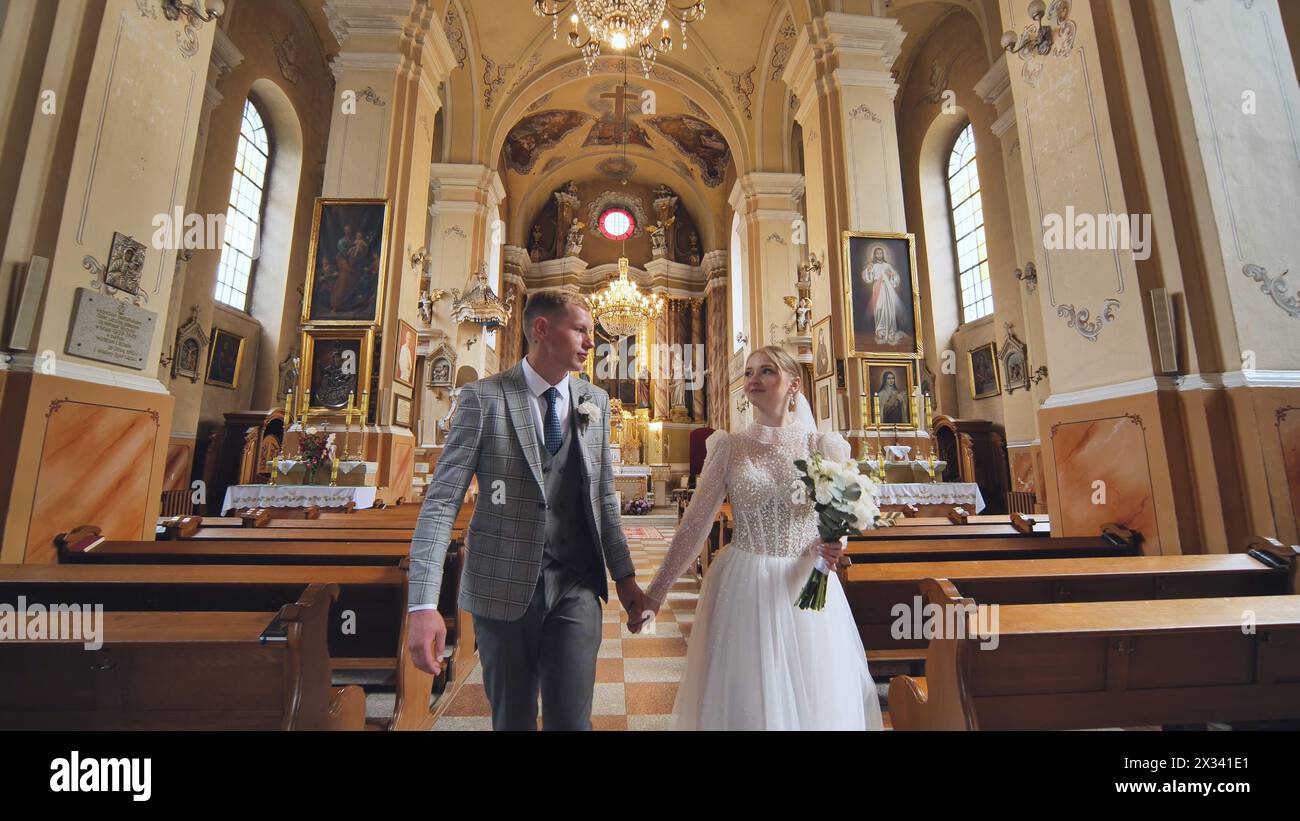 The bride and groom walk through a Catholic church Stock Photo - Alamy