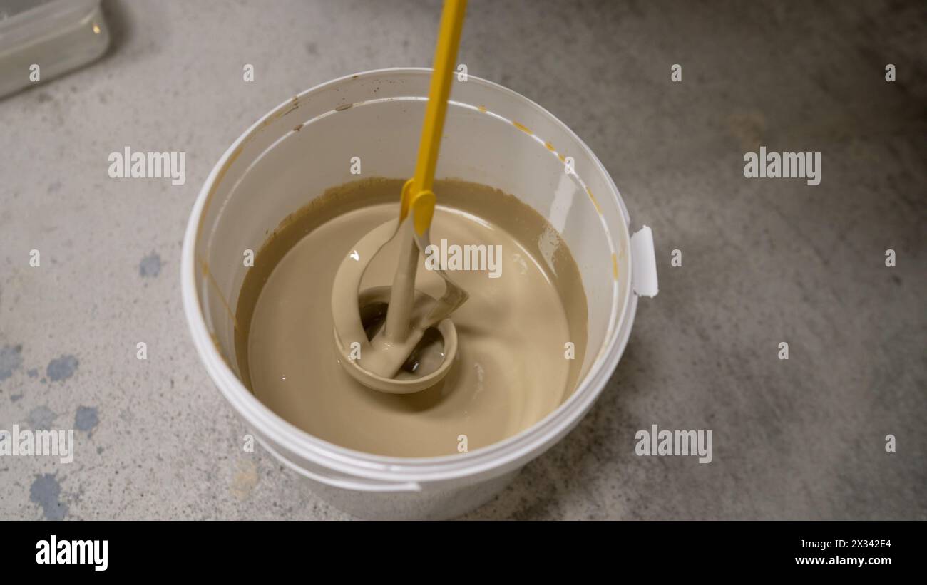 A bucket of hedgehog paint mixing in motion. A painter mixes paint ...