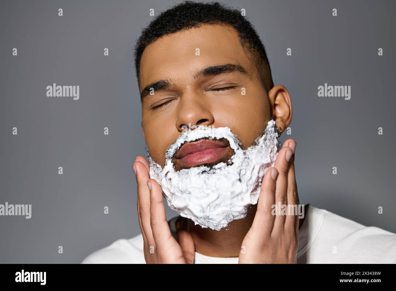 African american bearded man closely shaves his face as part of a ...