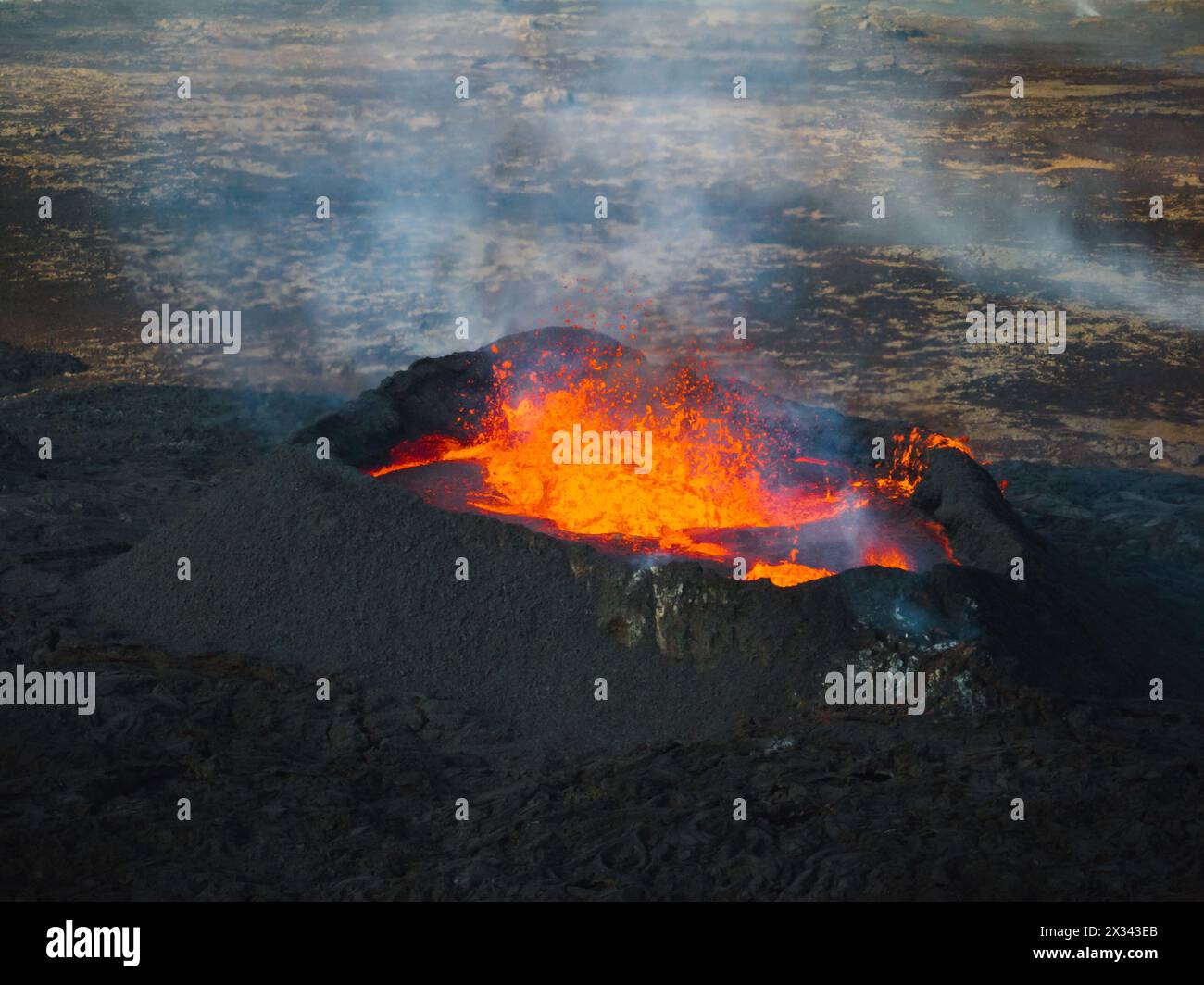 Dramatic view of an erupted volcano, red magma boiling in a crater ...