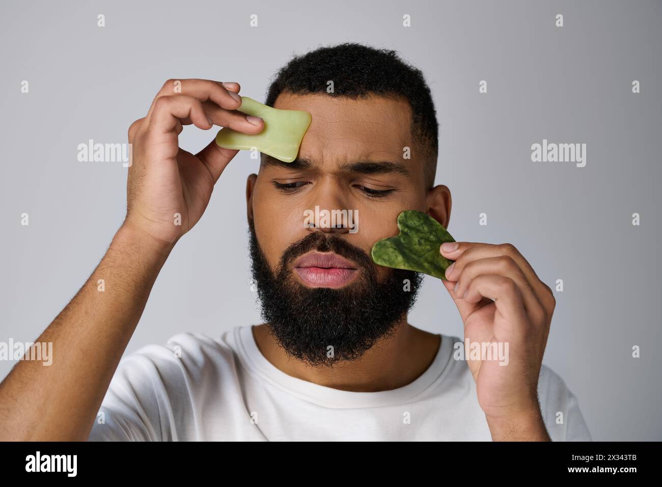African american handsome man holds gua sha for skincare routine Stock ... African american handsome man holds gua sha for skincare routine Stock ...