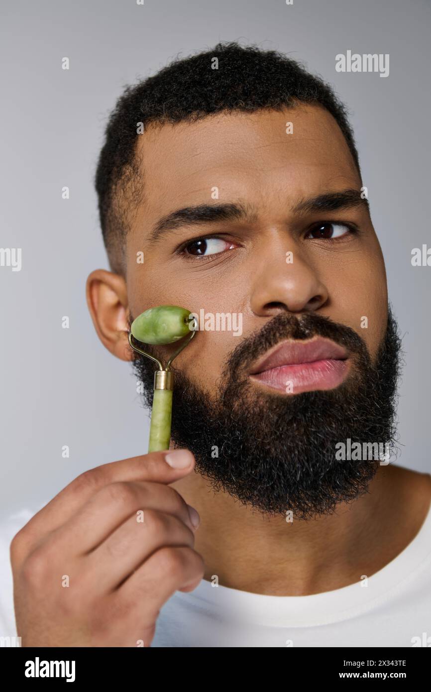 Bearded man holds face roller for skincare routine Stock Photo - Alamy Bearded man holds face roller for skincare routine Stock Photo - Alamy