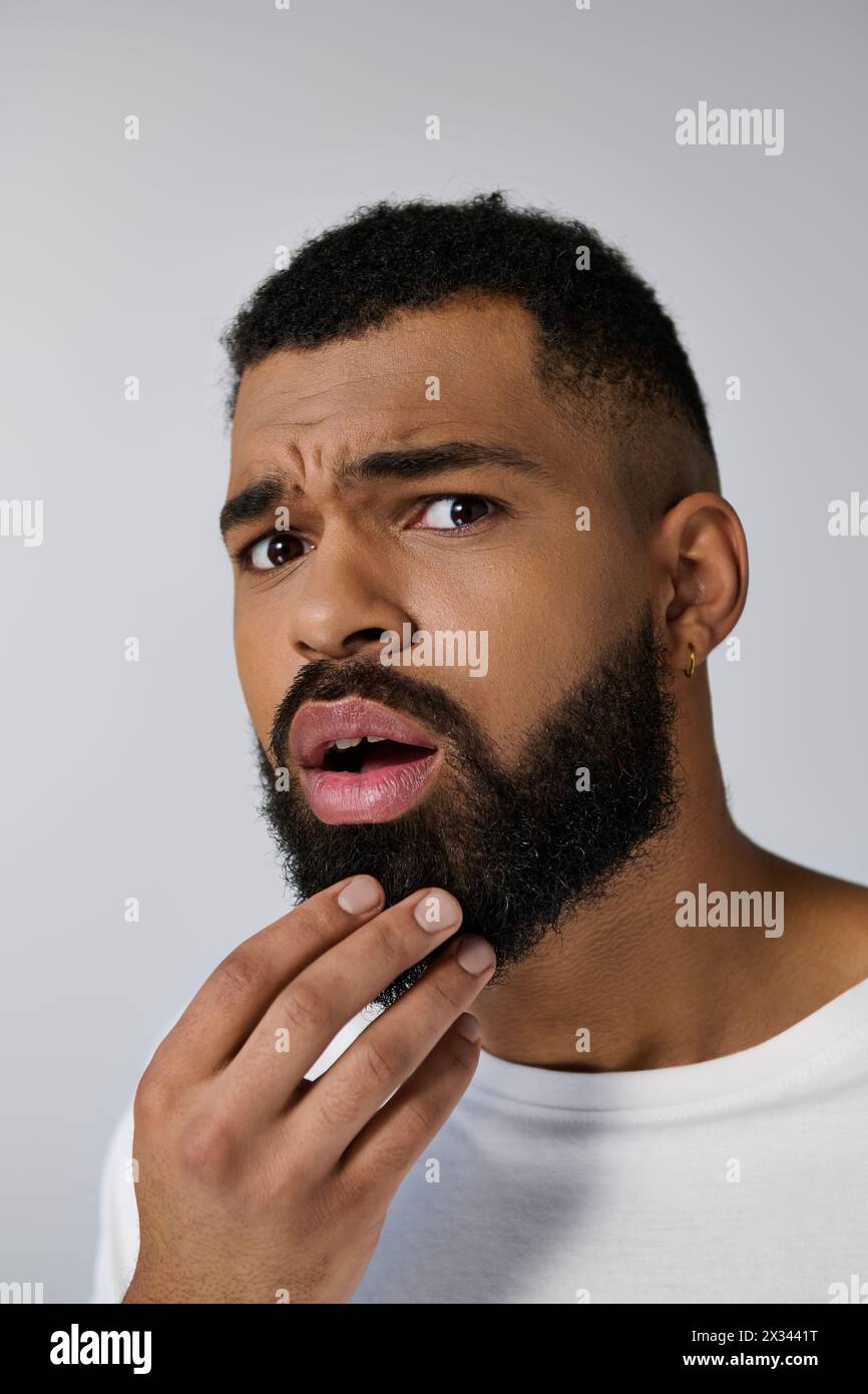 African american surprised man with a beard taking care of his hair ...