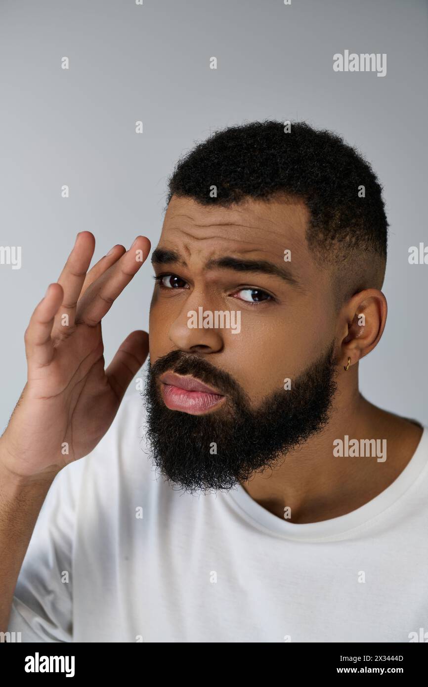 Handsome man in white t-shirt attending to his skin care routine Stock ...