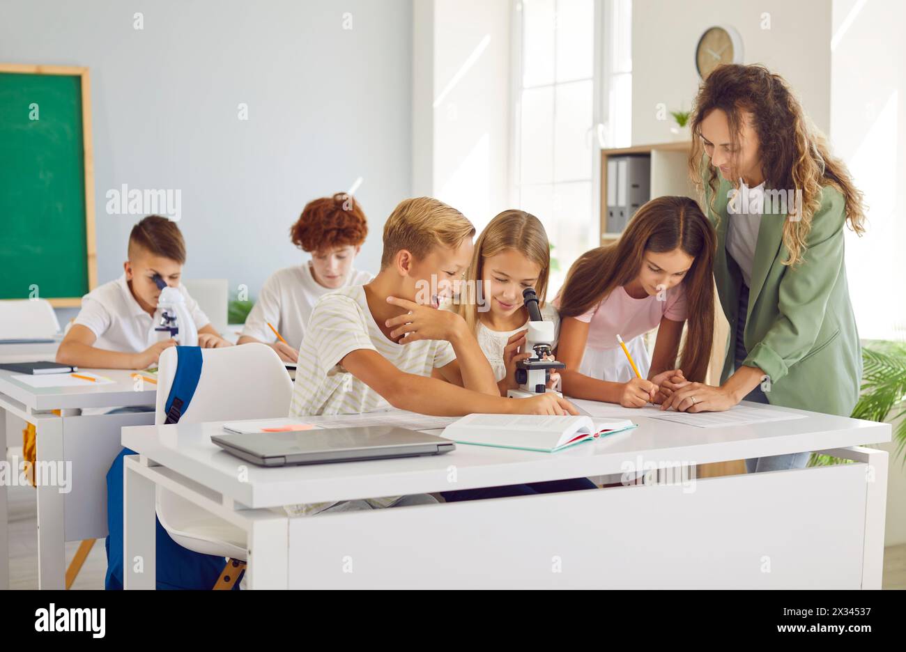 Teacher Assists Students During School Lesson in Classroom Stock Photo ...
