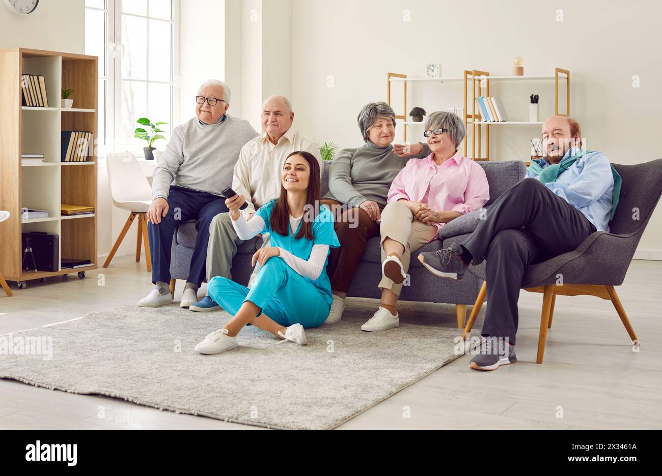 Group of diverse senior people watching TV in retirement home with ...