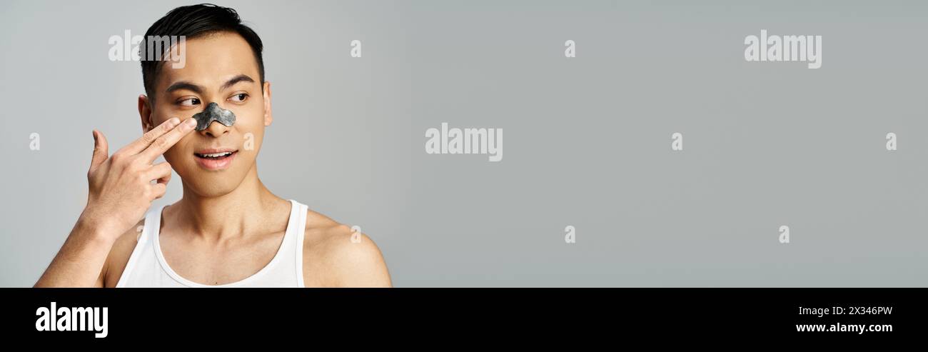 A handsome Asian man with a beauty nose patch for skincare routine ...