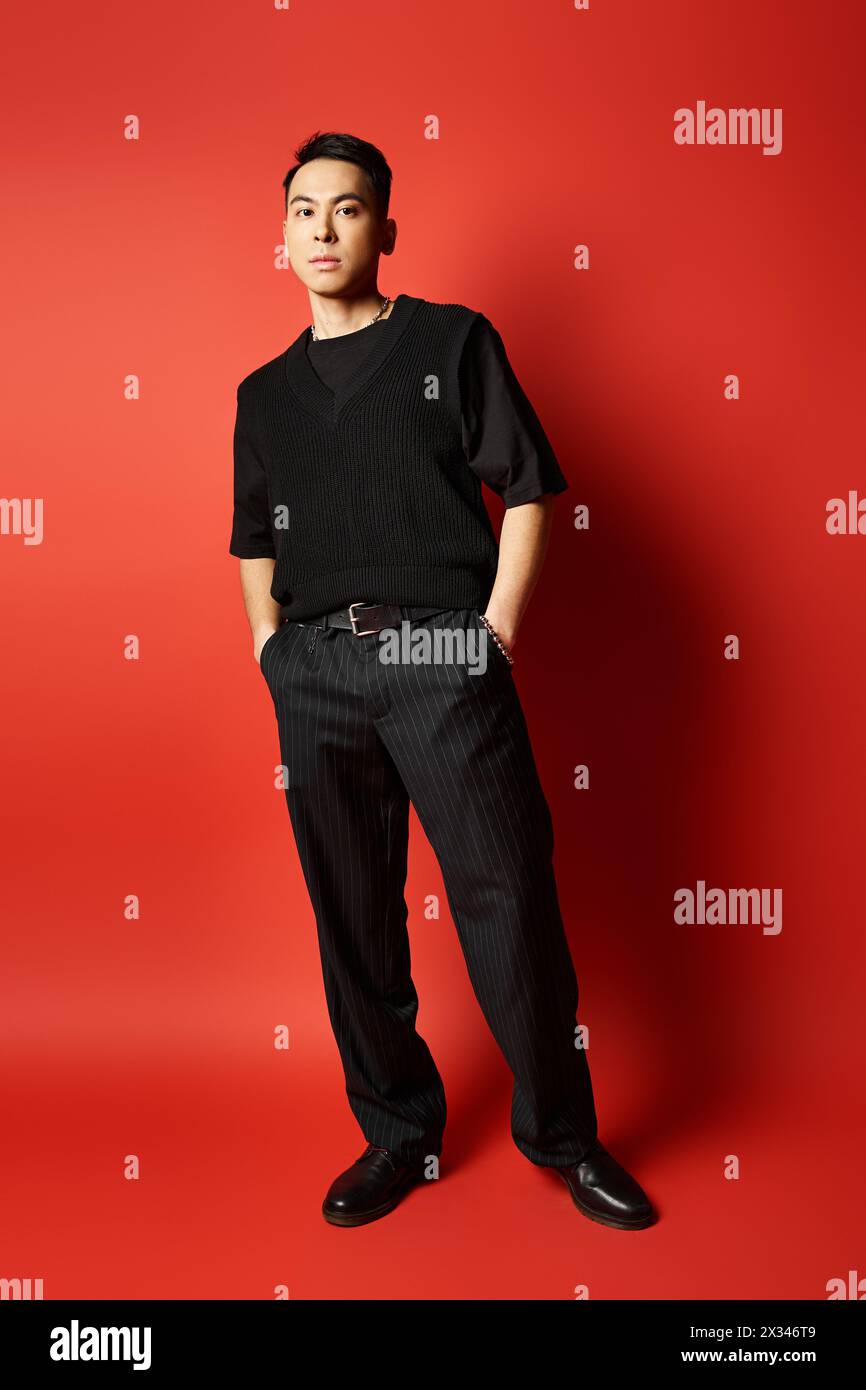 A stylish handsome Asian man stands confidently in black attire against ...