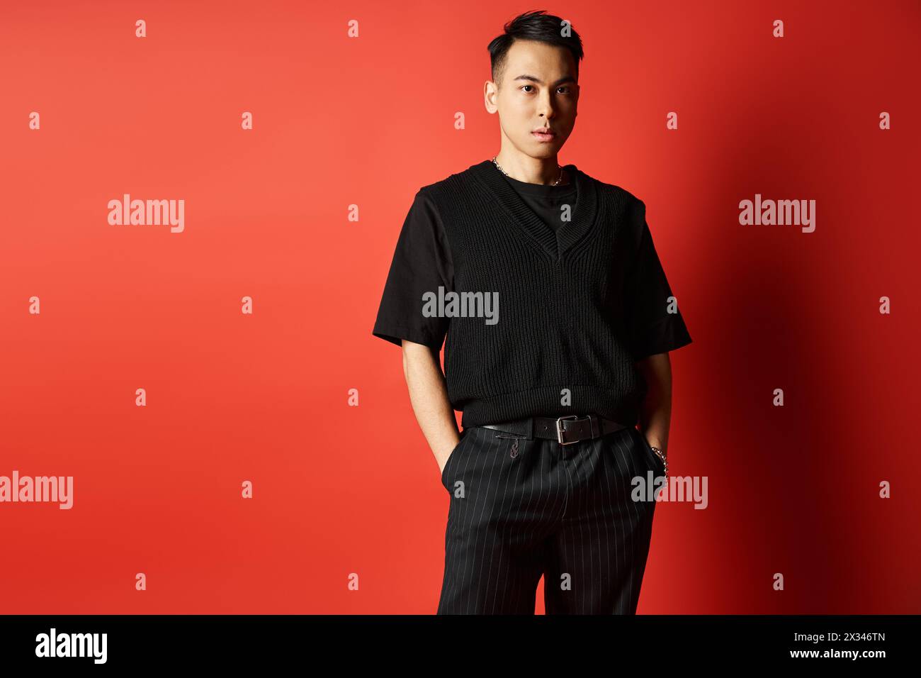 A stylish and handsome Asian man in black attire poses in front of a ...