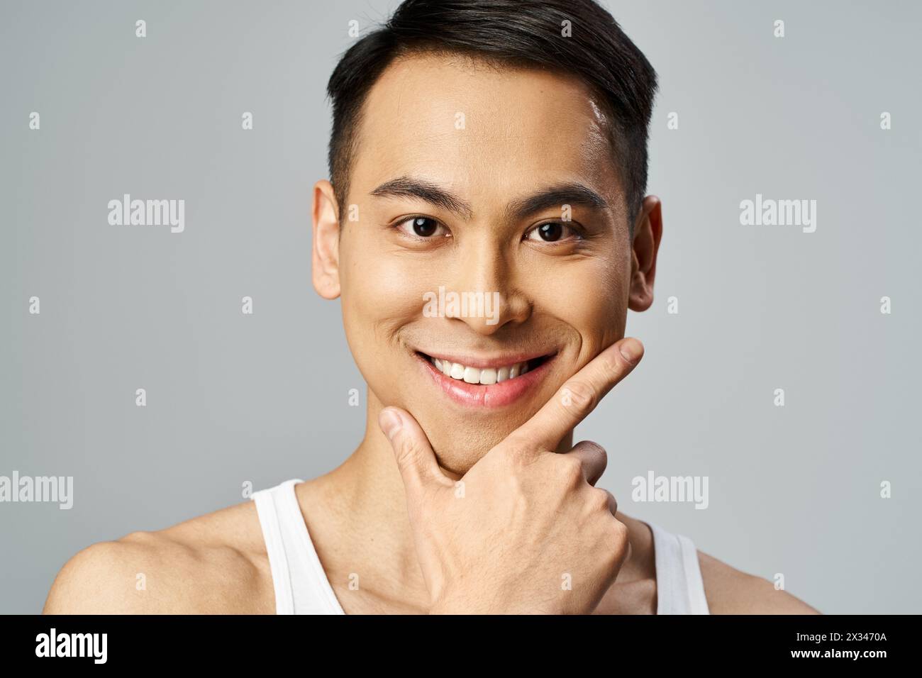A handsome Asian man with a smile on his face, exuding happiness and ...