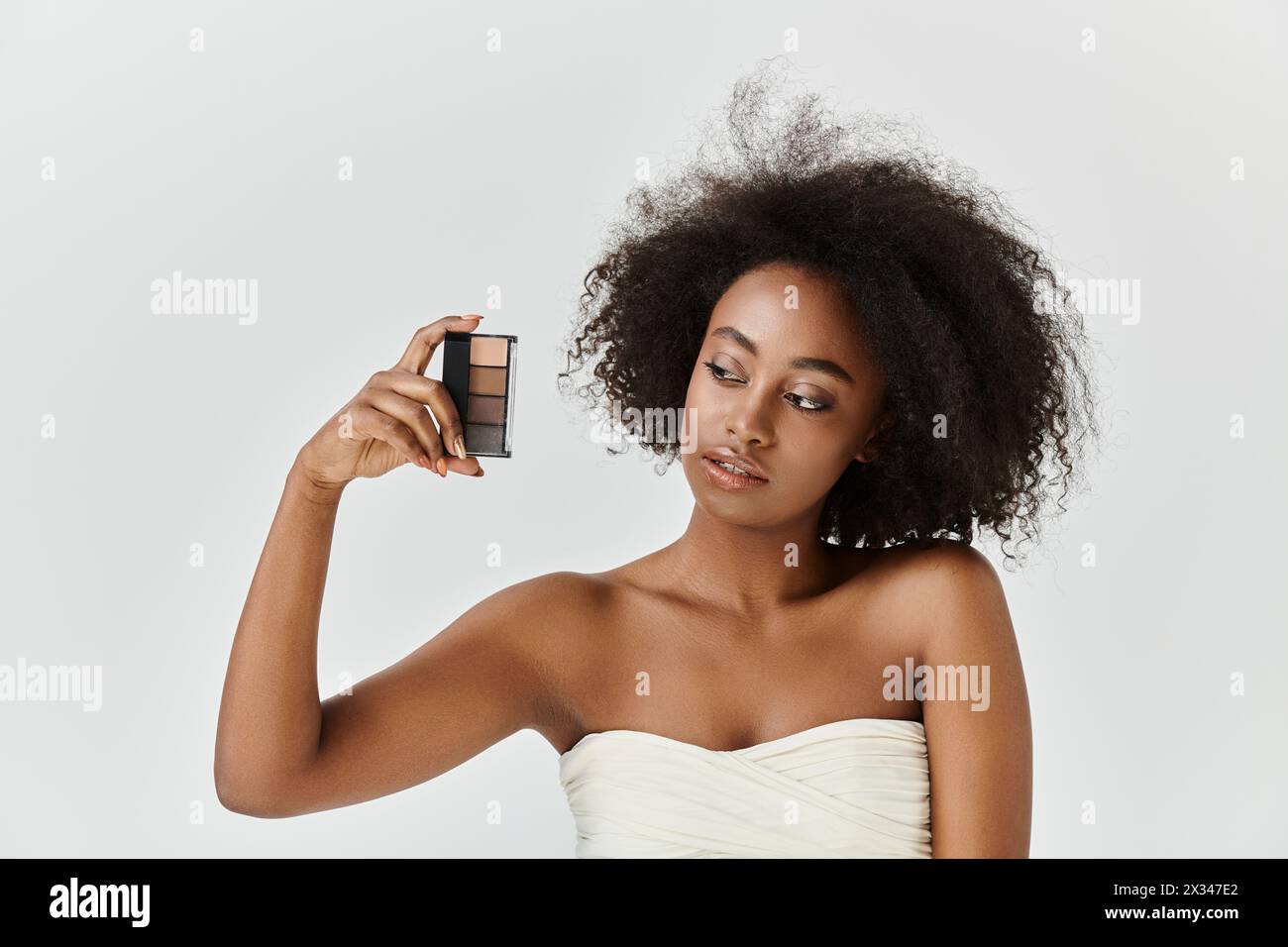A stunning African American woman with curly hair, wearing a white ...