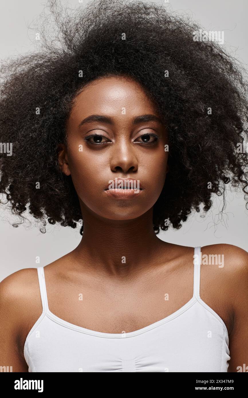 A stylish African American woman with a voluminous afro strikes a ...