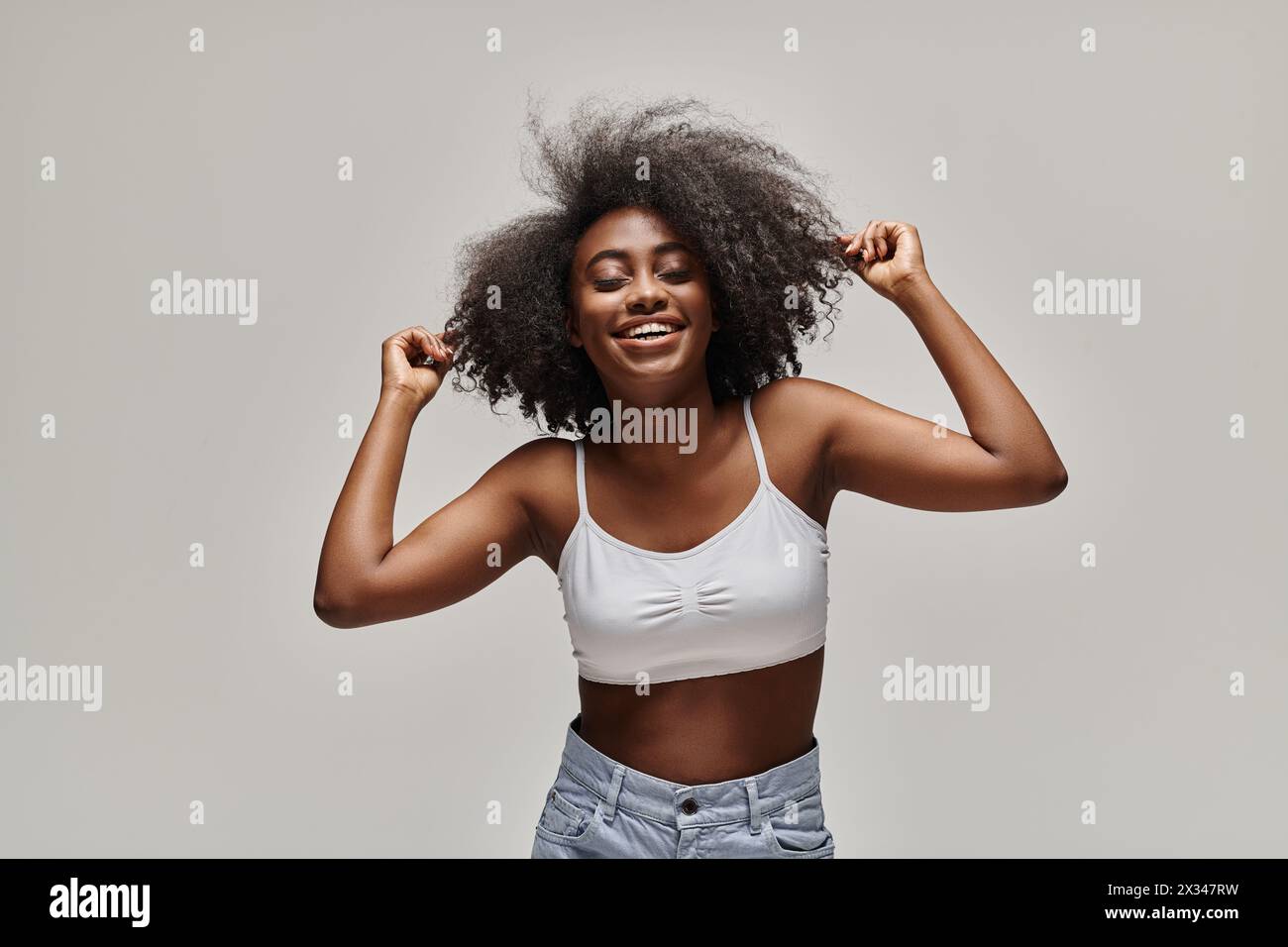 A beautiful young African American woman with curly hair flowing ...