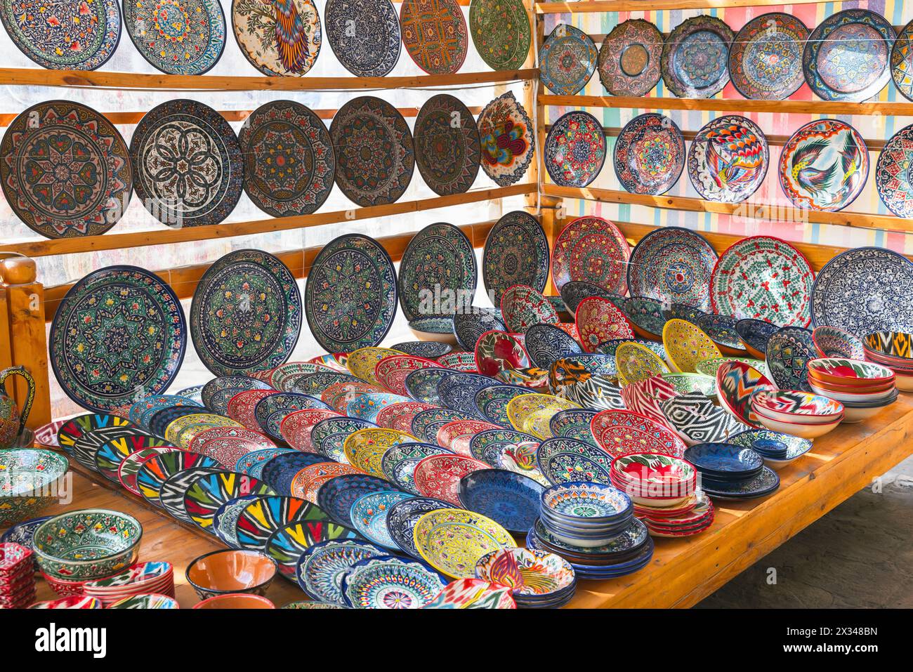 An assortment of handmade Uzbek plates and bowls with colorful ...