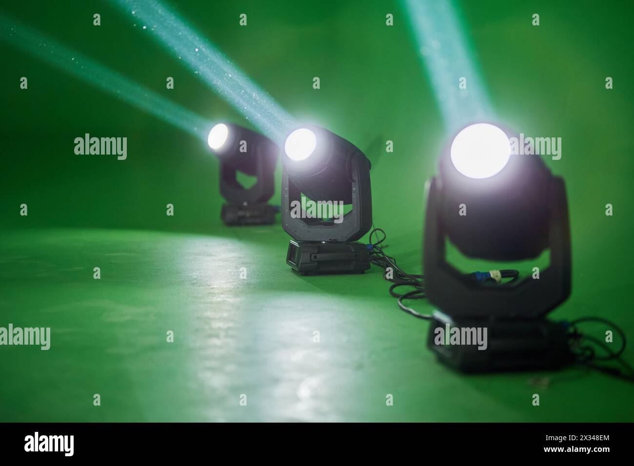 Three spotlights and light rays in dark green room Stock Photo - Alamy