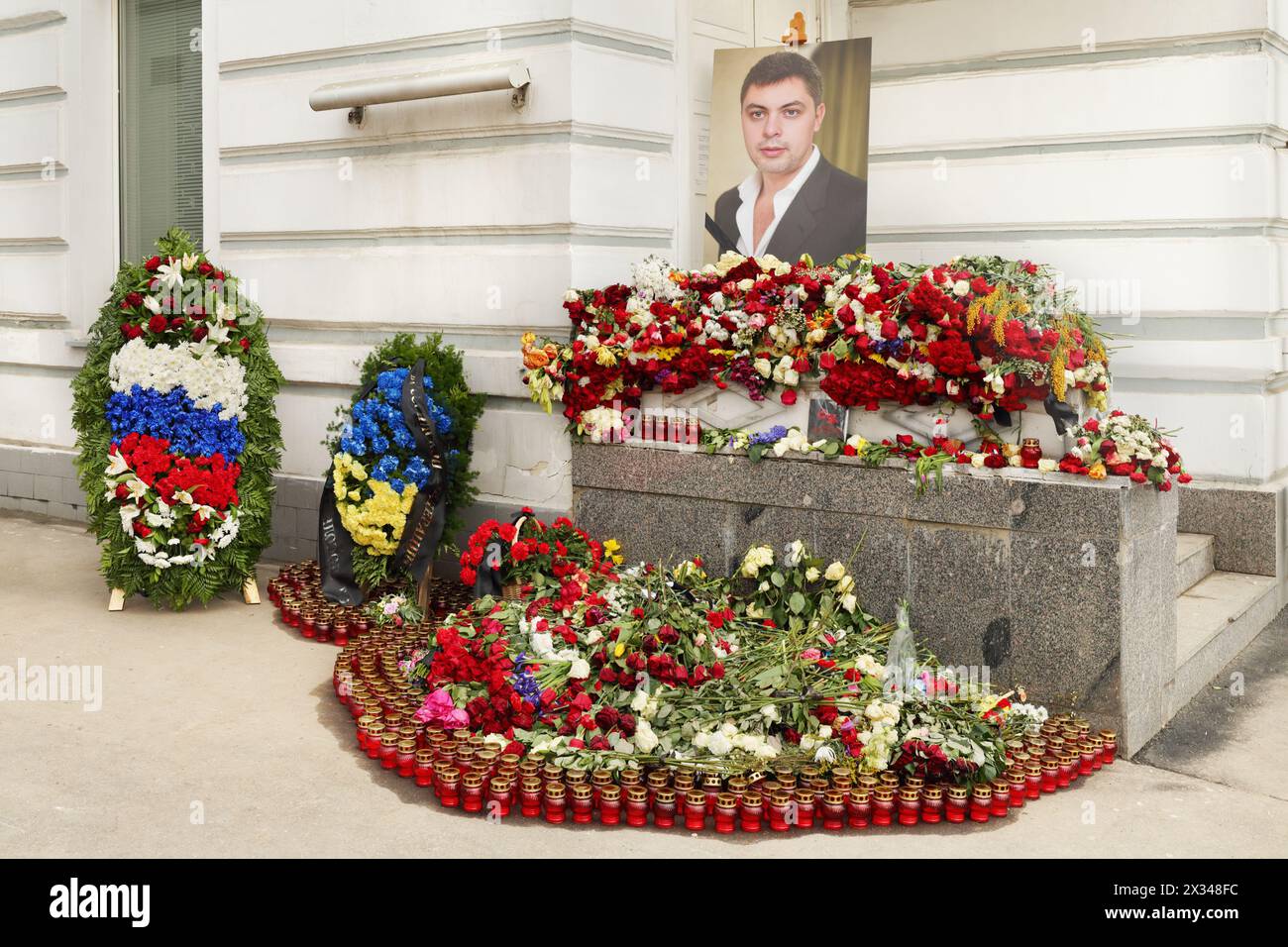 Flowers and wreaths at scene of murder with portrait Stock Photo - Alamy