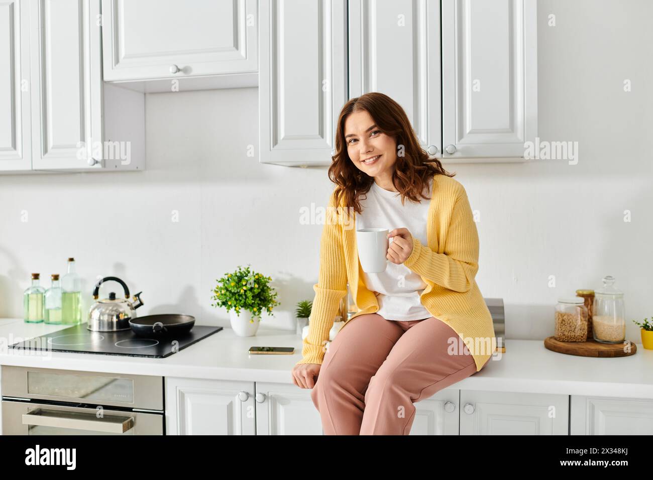 A middle aged woman sitting gracefully on a kitchen counter Stock Photo ...