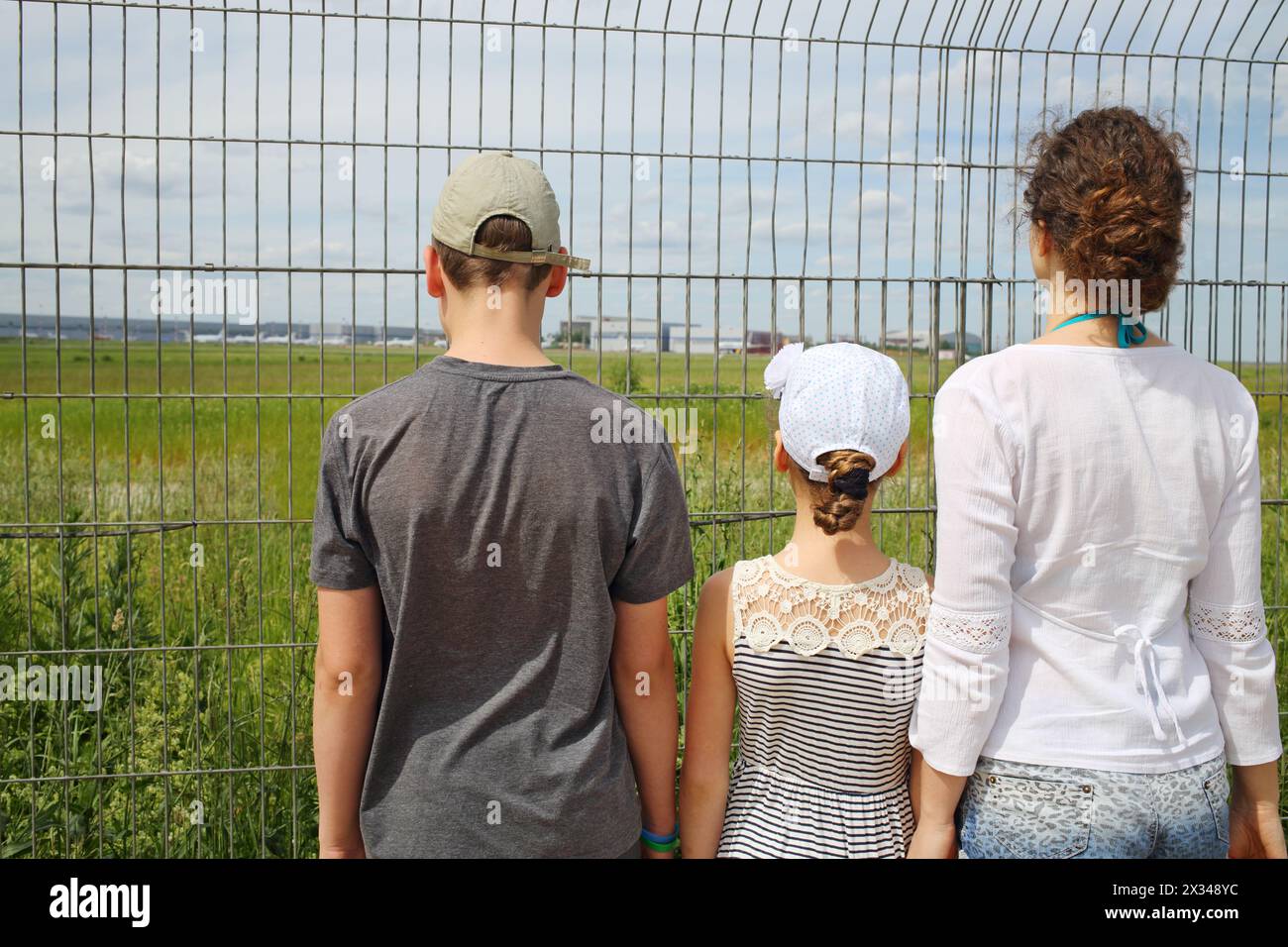 Boy standing behind fence hi-res stock photography and images - Alamy